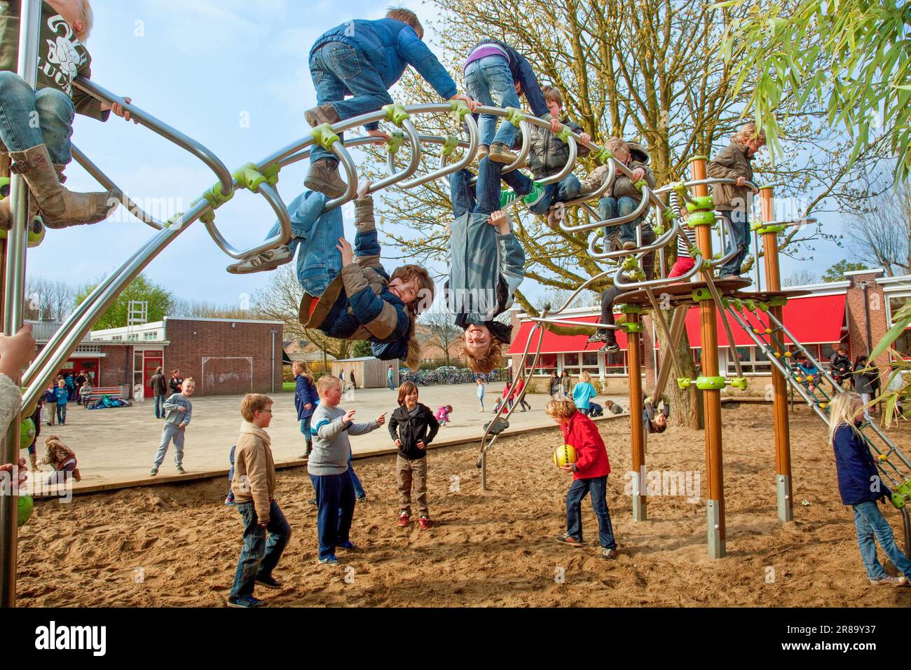 Netherlands, Schoolyard with children playing in and around a ...