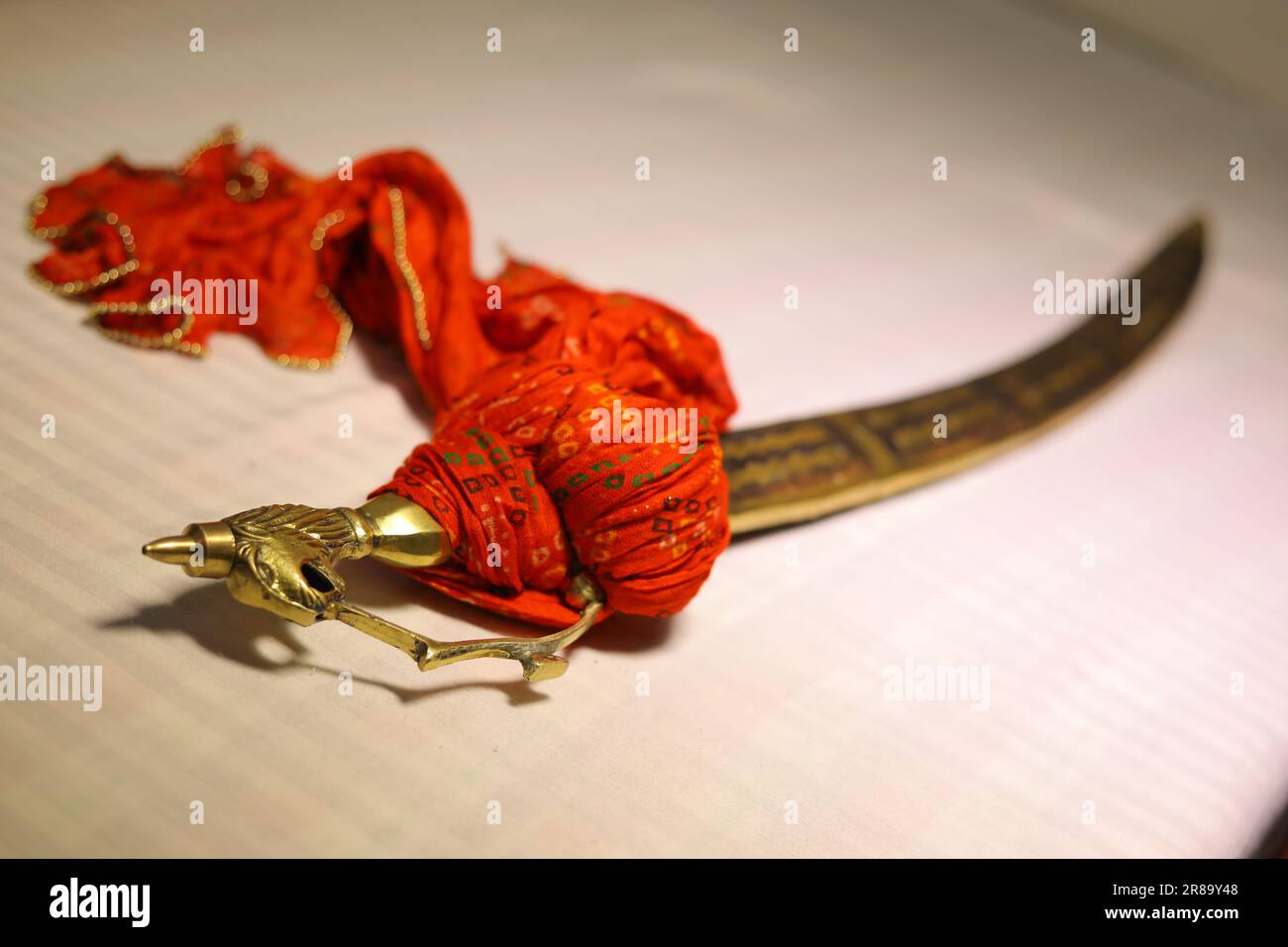 A metallic sword with an intricate design, the handle of the weapon is ...