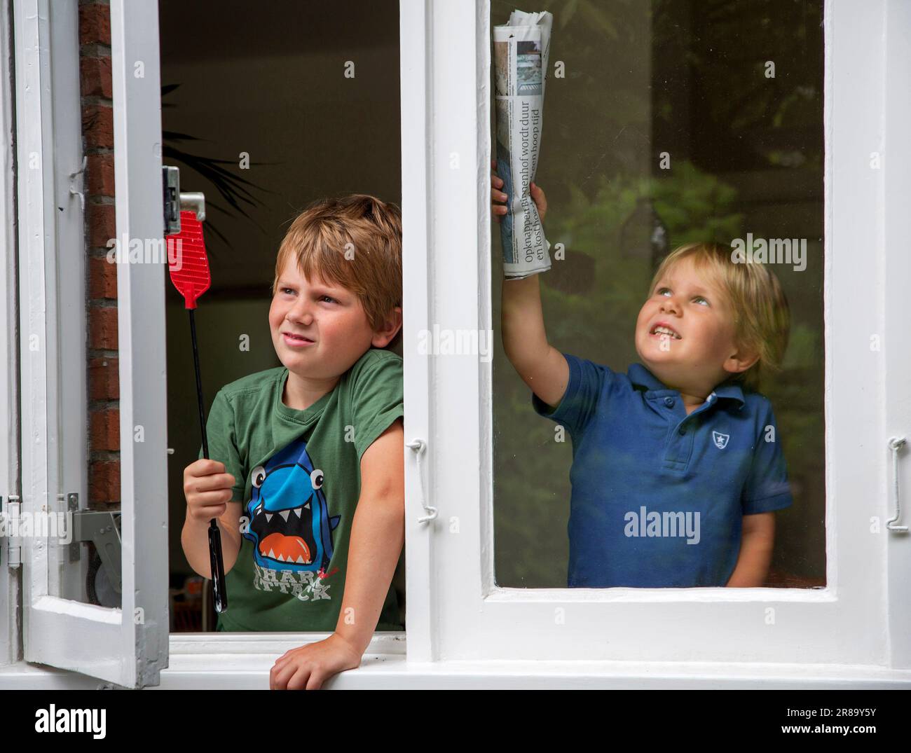 Netherlands, children chase a fly through an open window with fly ...