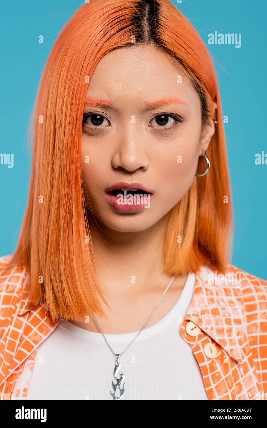 shocked face, young asian woman with red hair looking at camera and ...