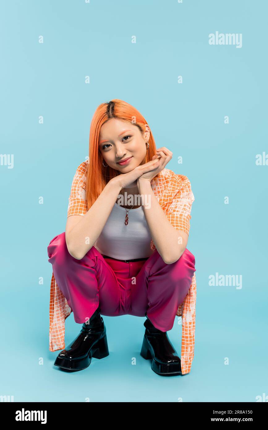 young and stylish asian woman with pleased face expression posing on ...