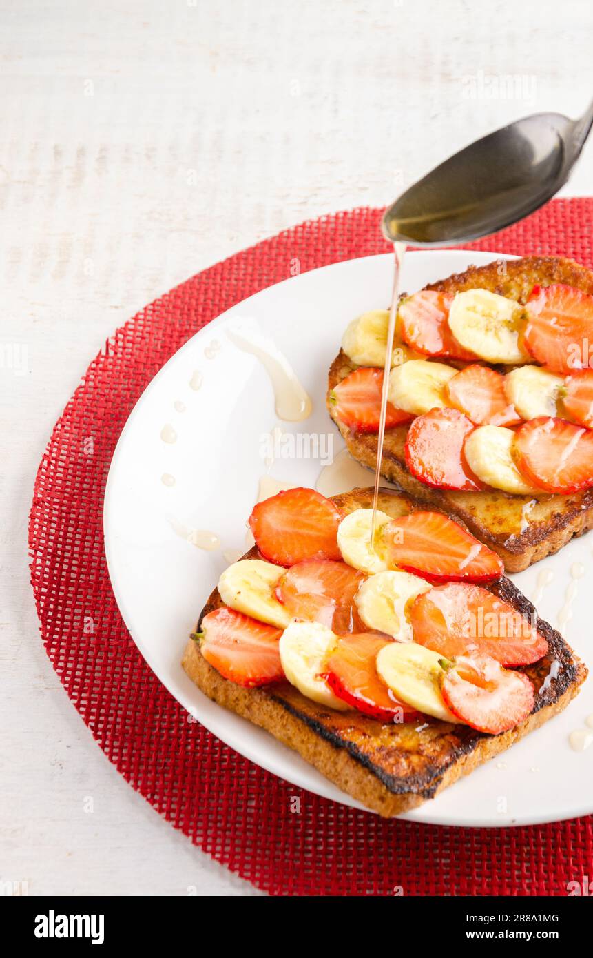 French toast with strawberries, banana and honey. White background ...