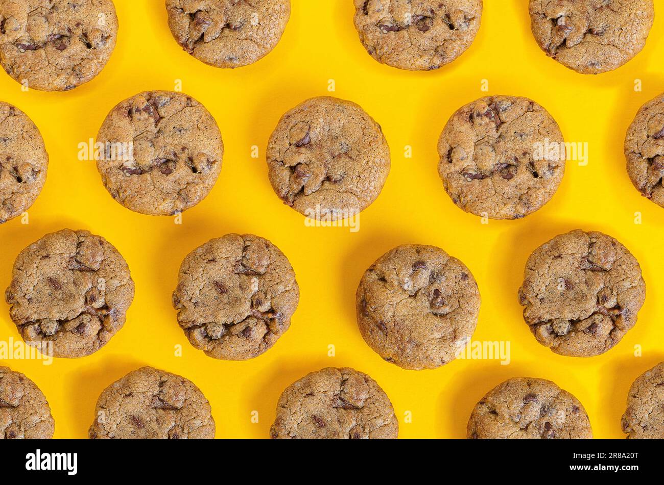 Chocolate chip cookie pattern on yellow background Stock Photo - Alamy