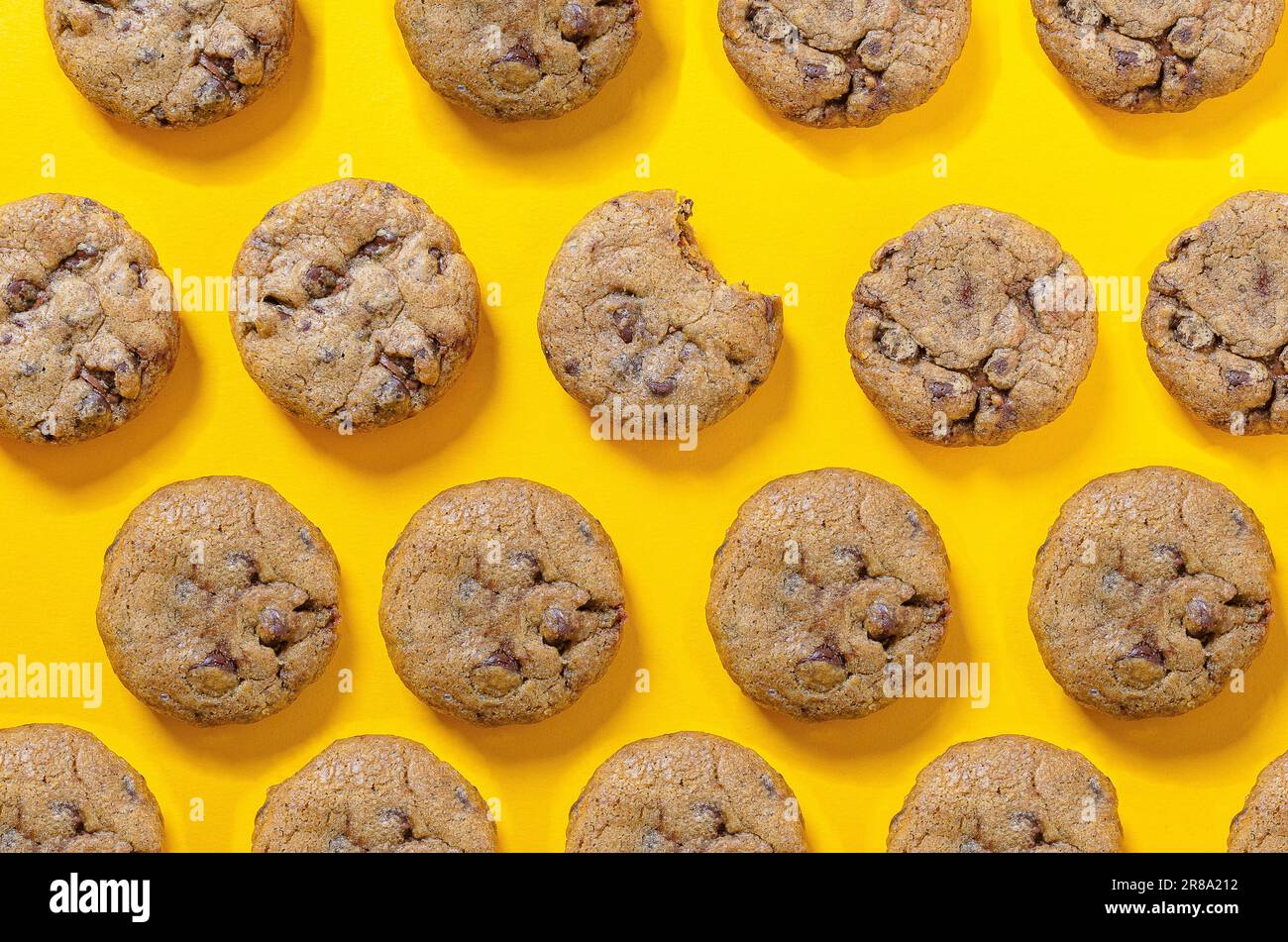 Chocolate chip cookie pattern on yellow background Stock Photo - Alamy