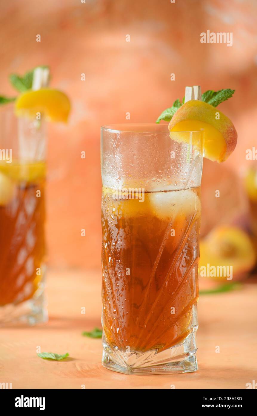 peach iced tea Jug in the background. Shadows on a melon-colored ...