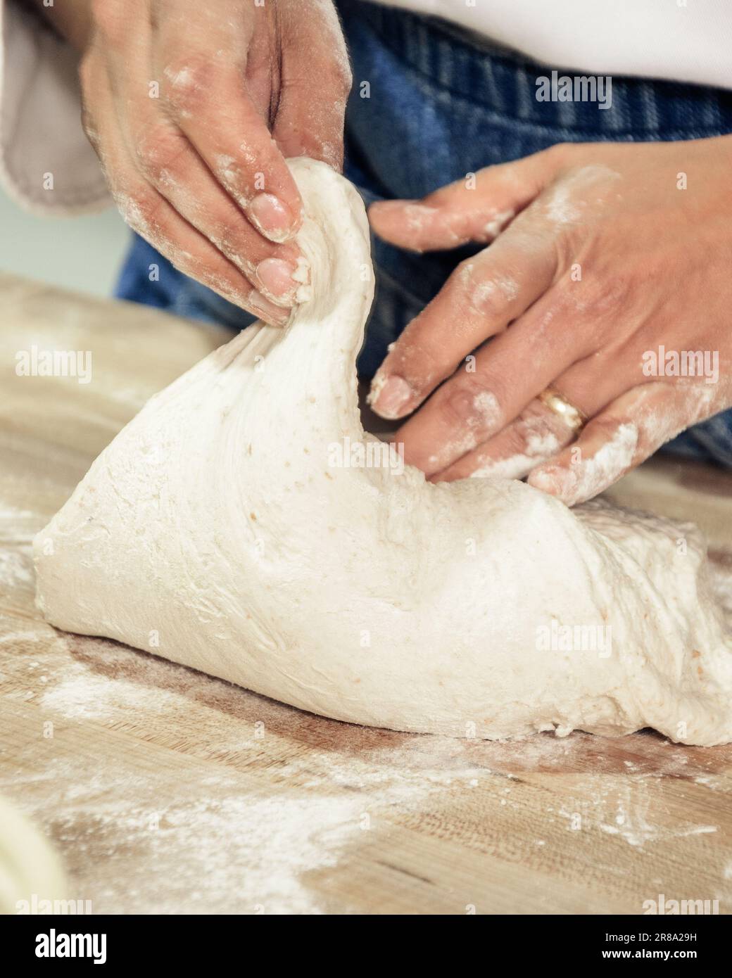 Kneading and preparation of sourdough-based bread. On a wooden table ...
