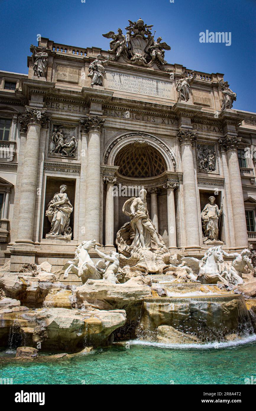 The Trevi Fountain in Rome, Italy. Shown on a hot summer's day looking over the water for ...