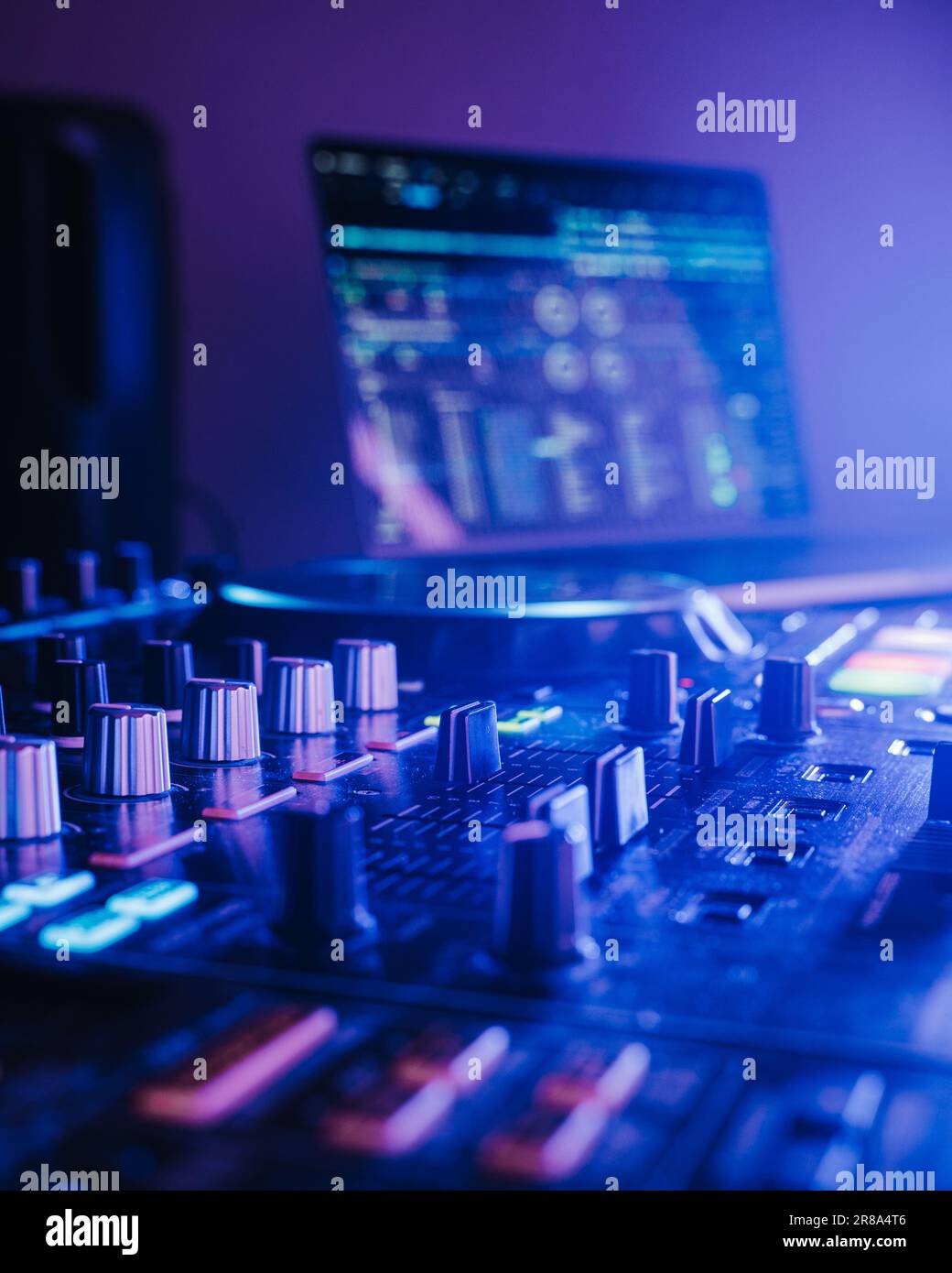 A professional audio mixing board connected to a laptop, displaying the ...