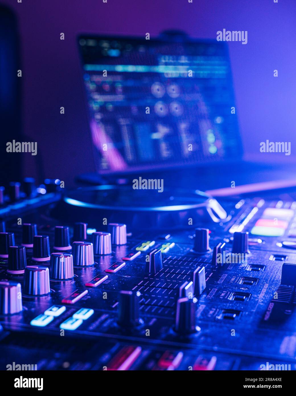 A professional audio mixing board connected to a laptop, displaying the ...