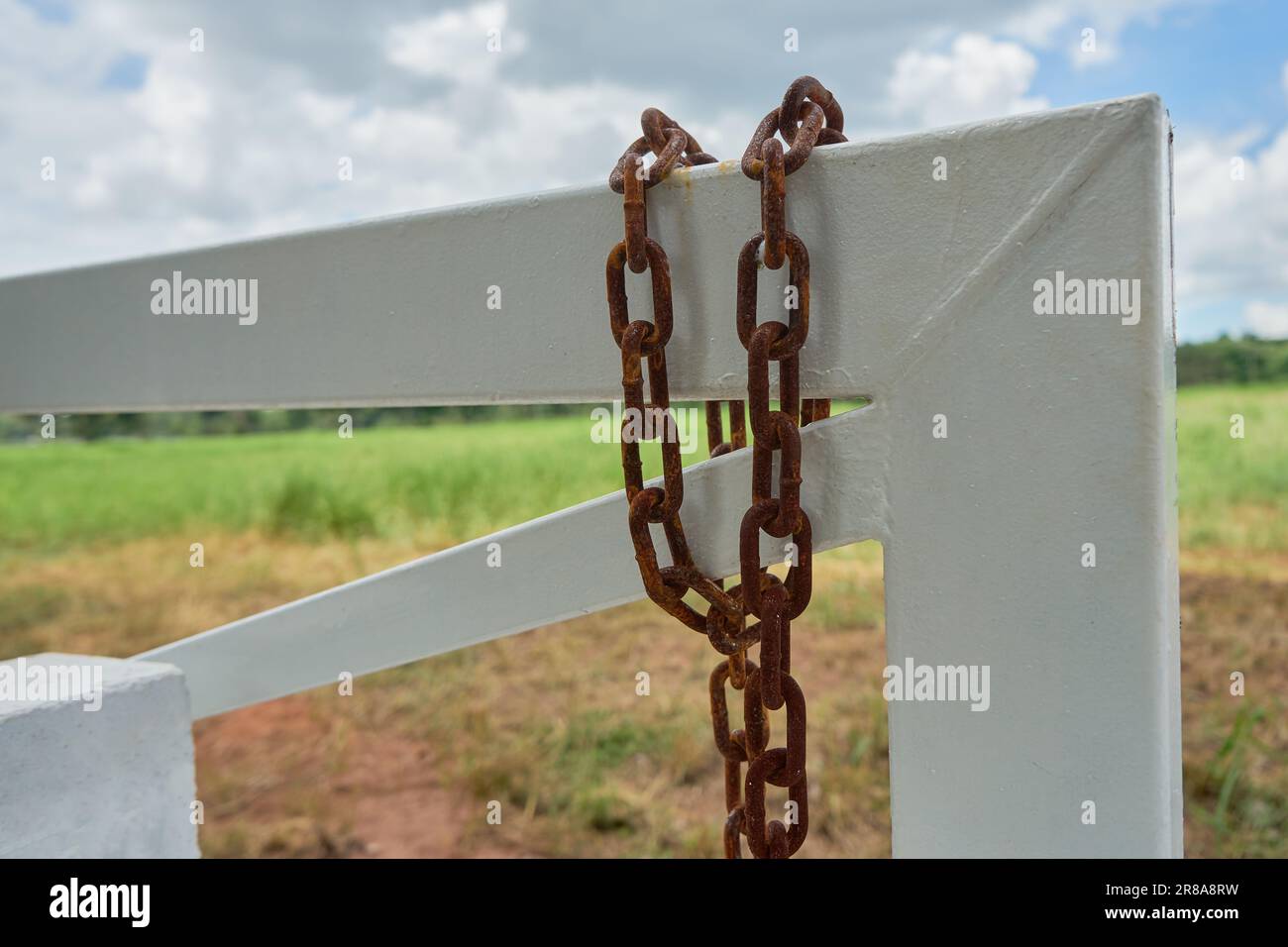 The rusty chain on a white gate Stock Photo - Alamy