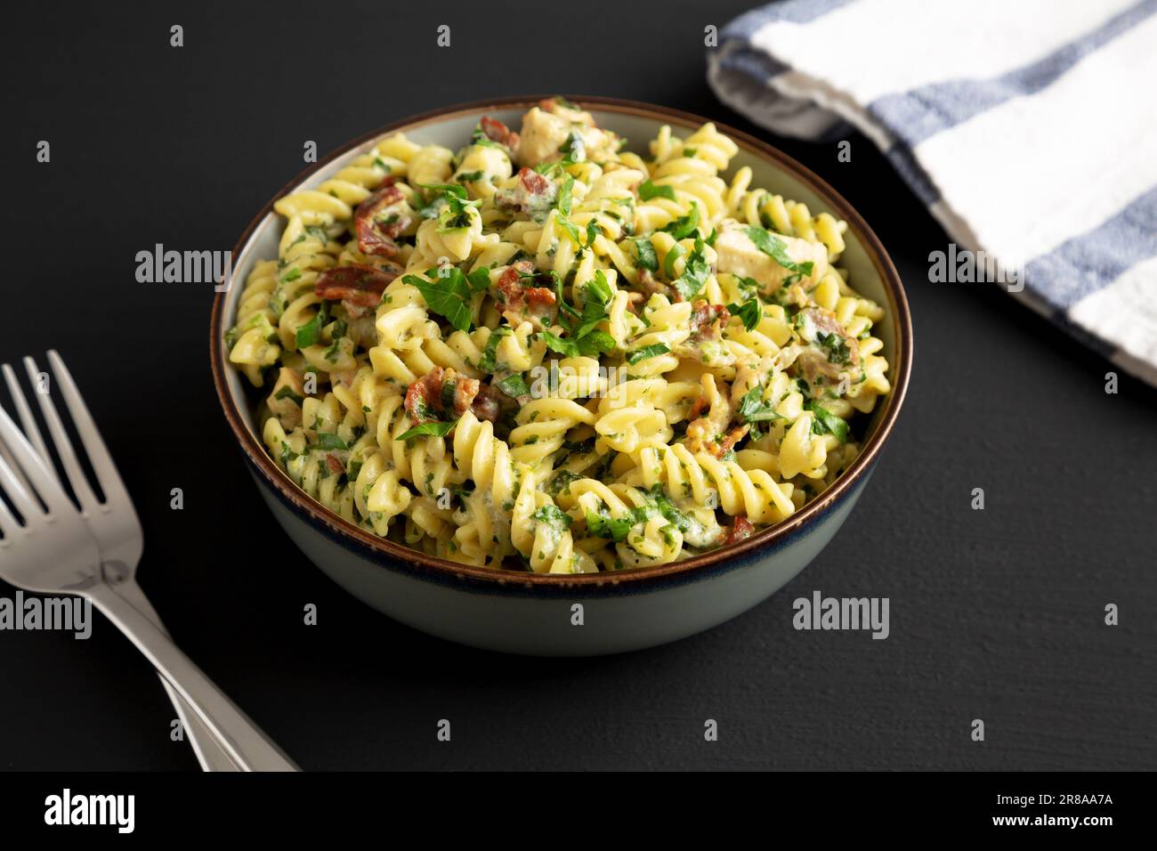 Homemade Chicken Spinach Alfredo Rotini Pasta in a Bowl on a black ...