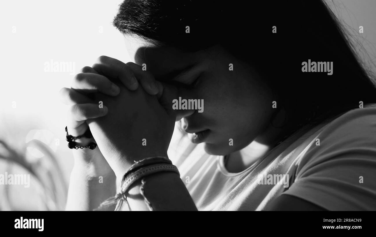 Dramatic Devotion of young woman Praying to God in monochrome black and ...