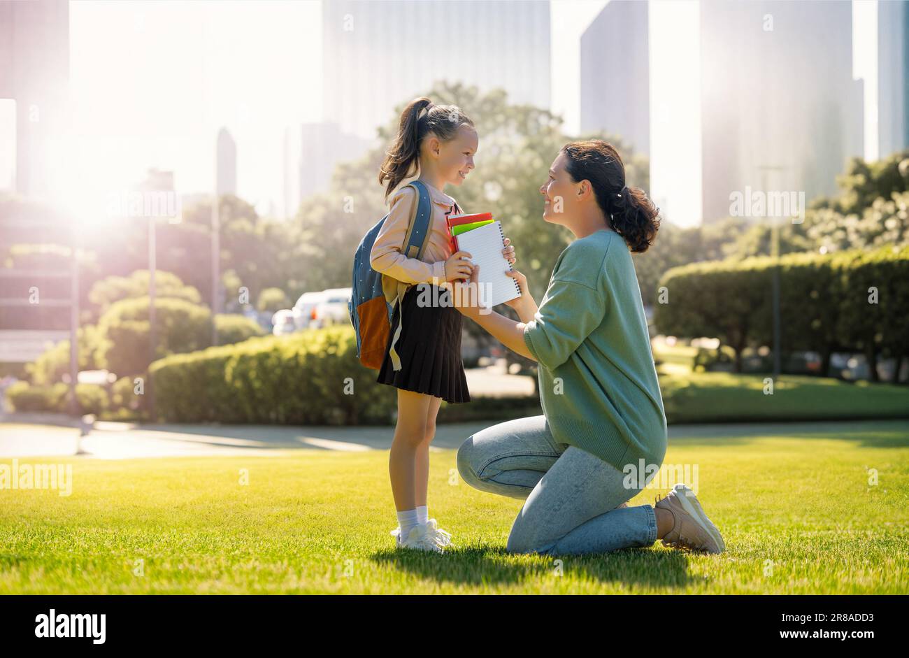 Parent and pupil of primary school going hand in hand. Woman and girl ...