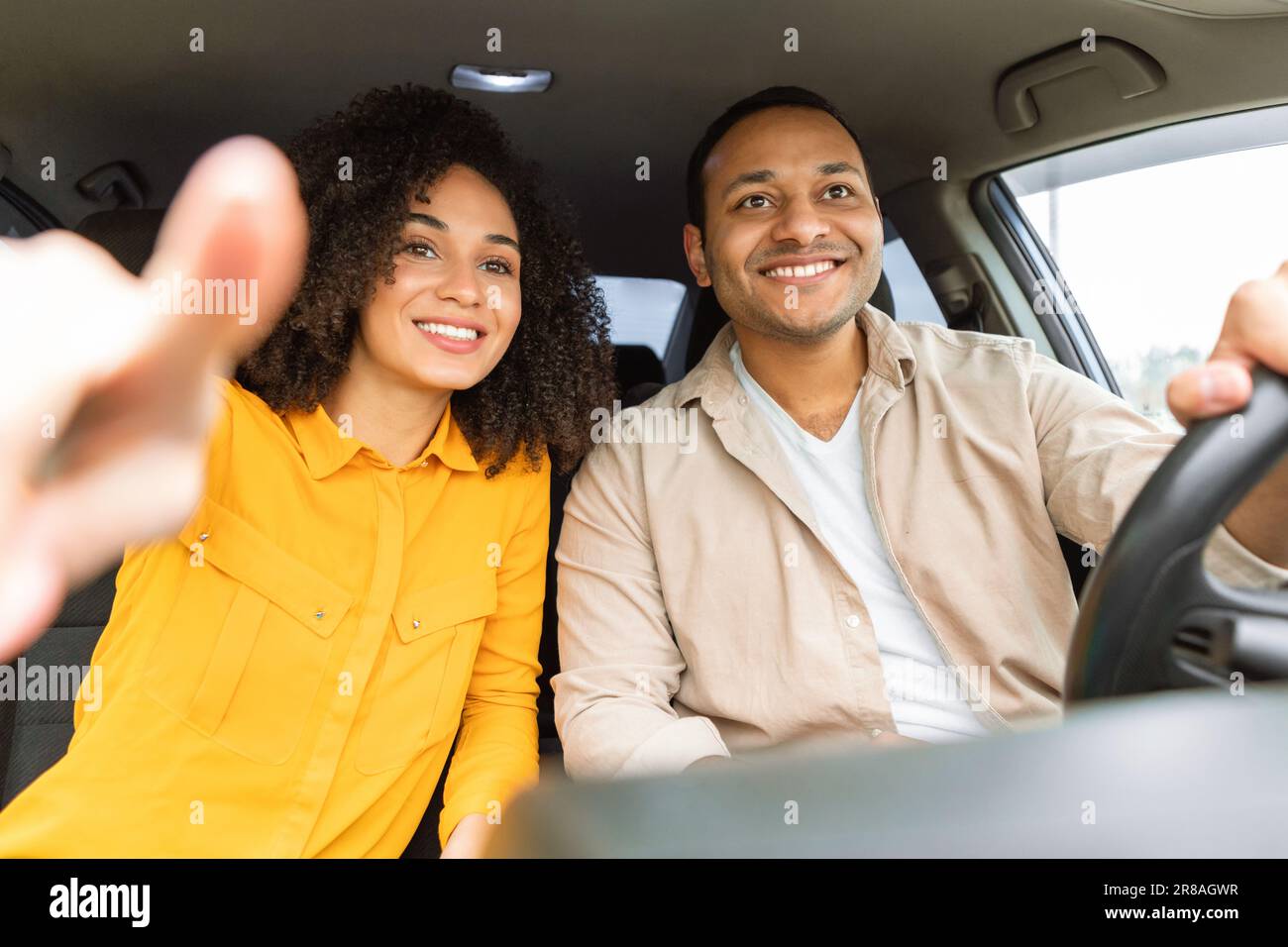 Happy young woman car pointing finger hi-res stock photography and ...