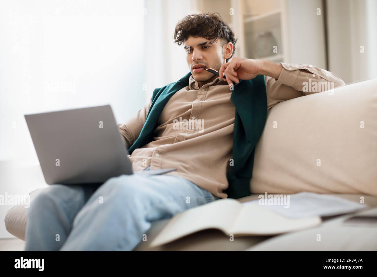 Thoughtful Arabic Guy Learning Via Laptop Computer Sitting At Home ...
