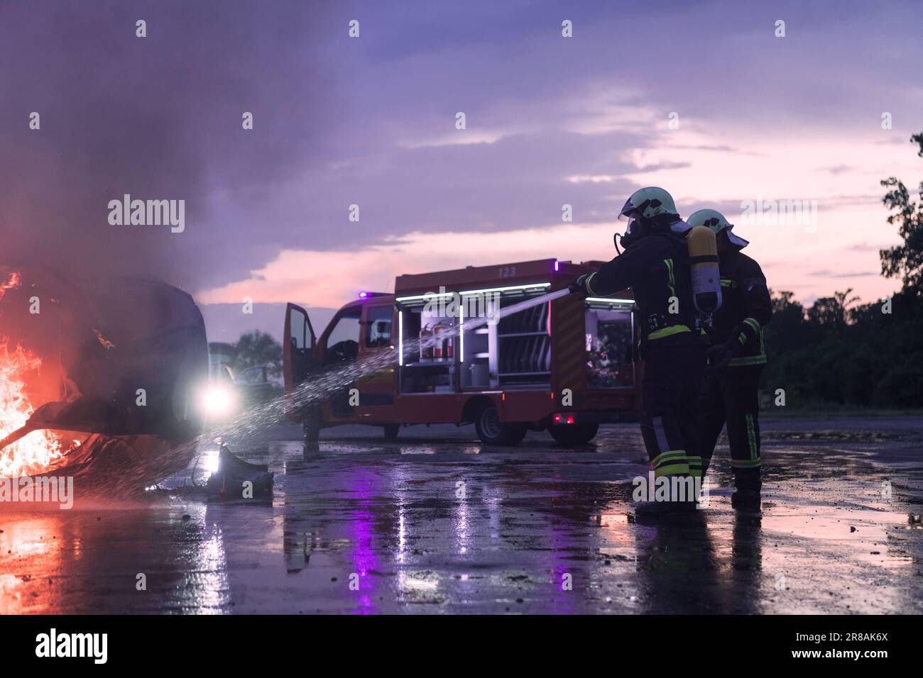 Firefighters using water fire extinguisher to fighting with the fire ...