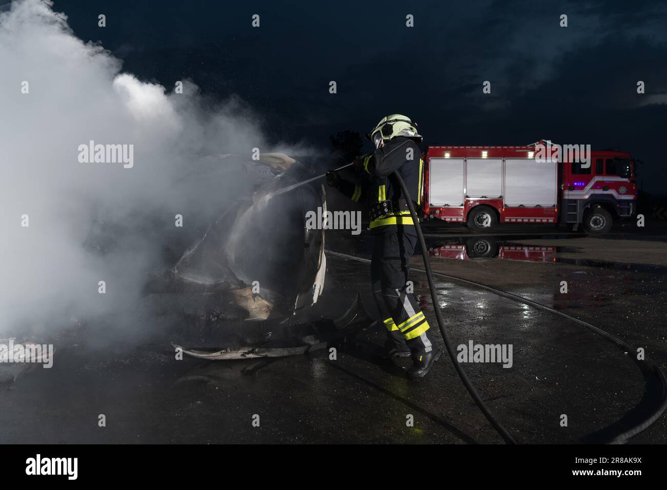 Firefighters using water fire extinguisher to fighting with the fire ...