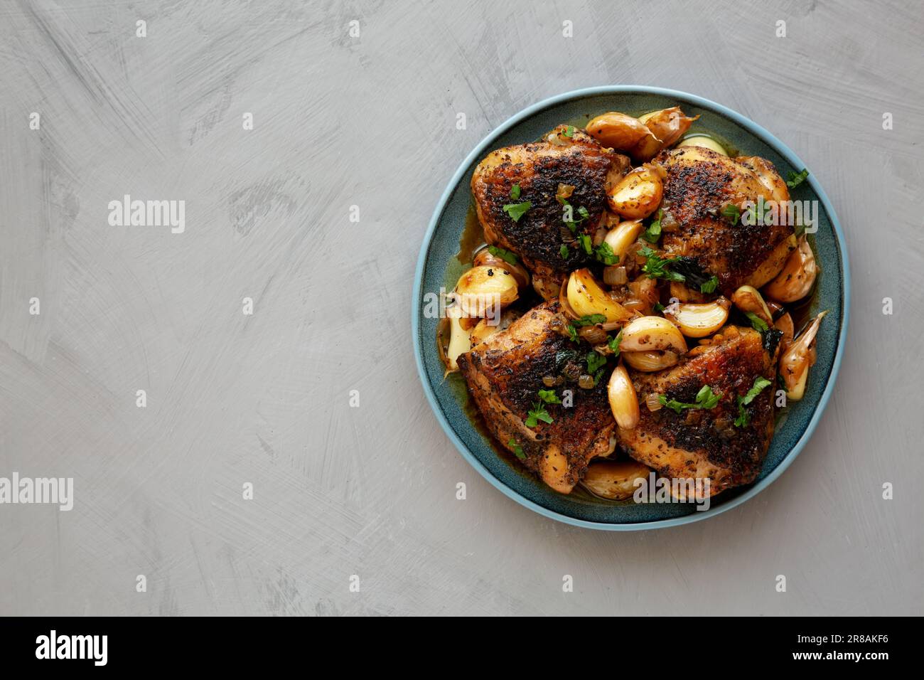 Homemade Chicken With 40 Cloves of Garlic on a Plate, top view. Flat ...