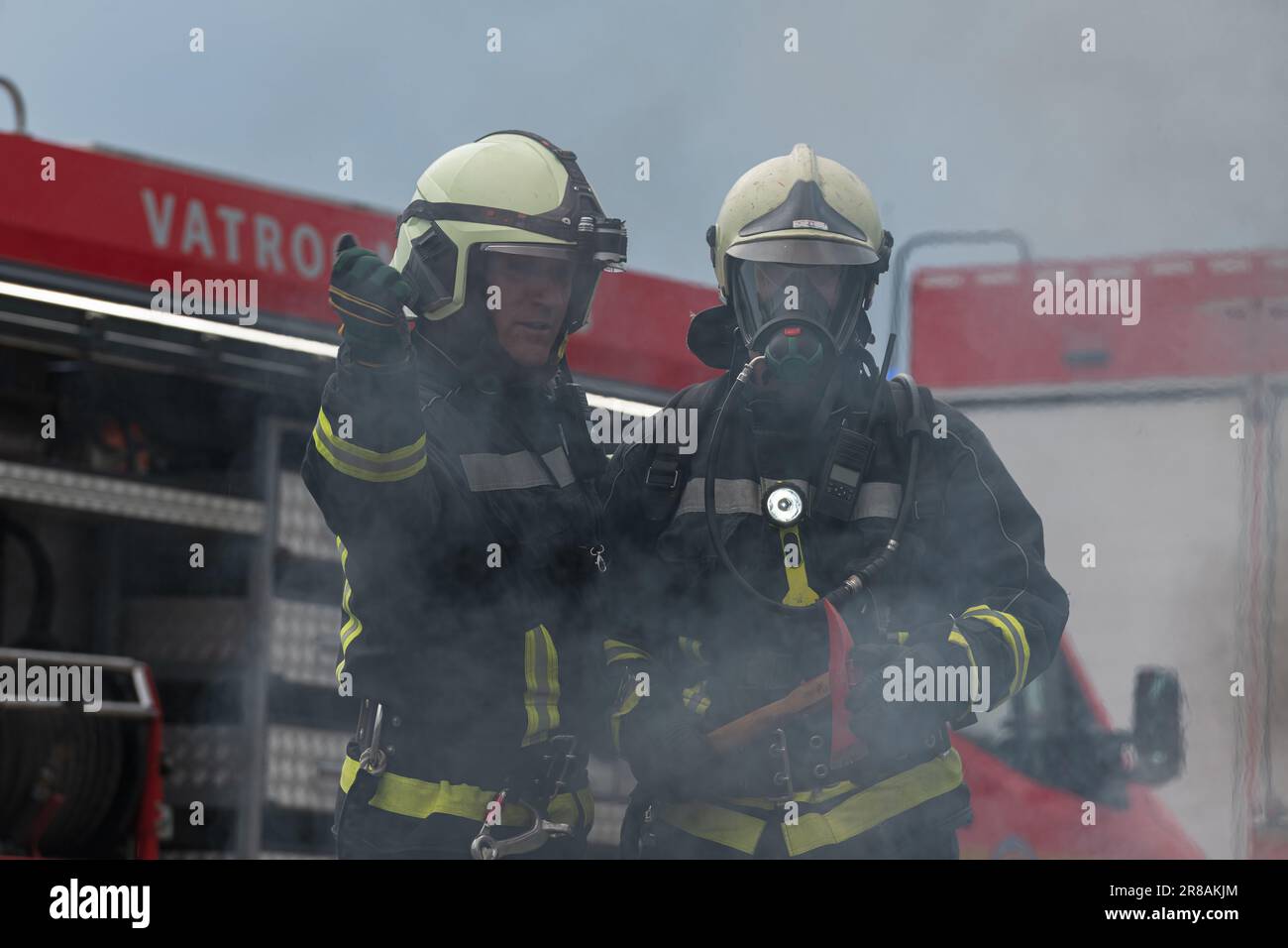 Firefighters using water fog type fire extinguisher to fighting with ...