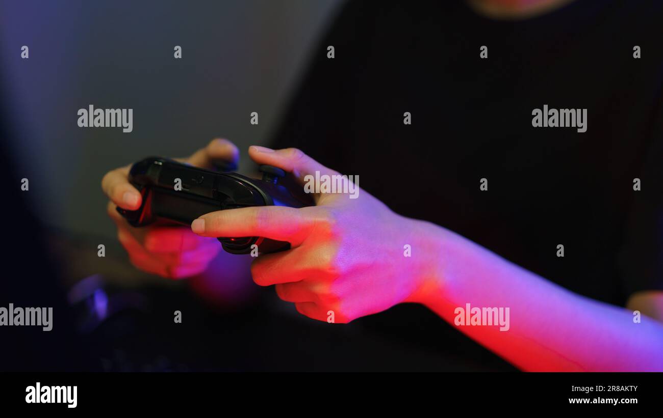 Hand of female cyber hacker gamer holding controller joystick to ...