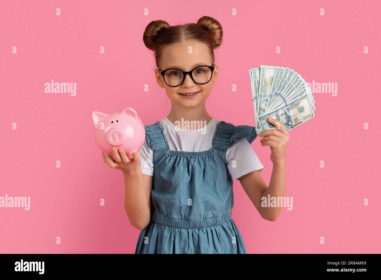 First Savings. Cute little girl holding dollar cash and piggy bank ...