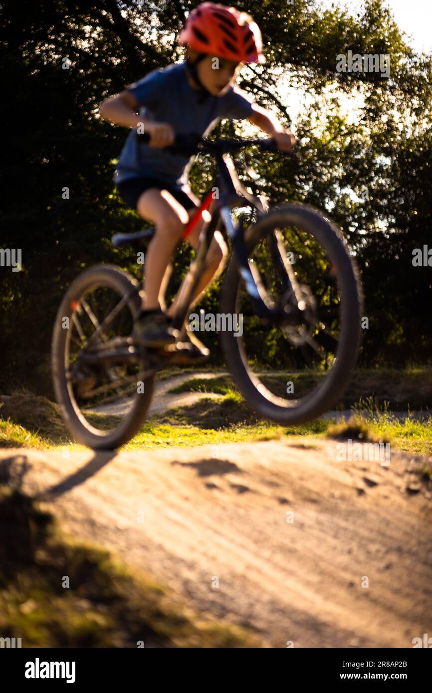Little boy riding with his bike on a pumptrack (focus on the trees in ...