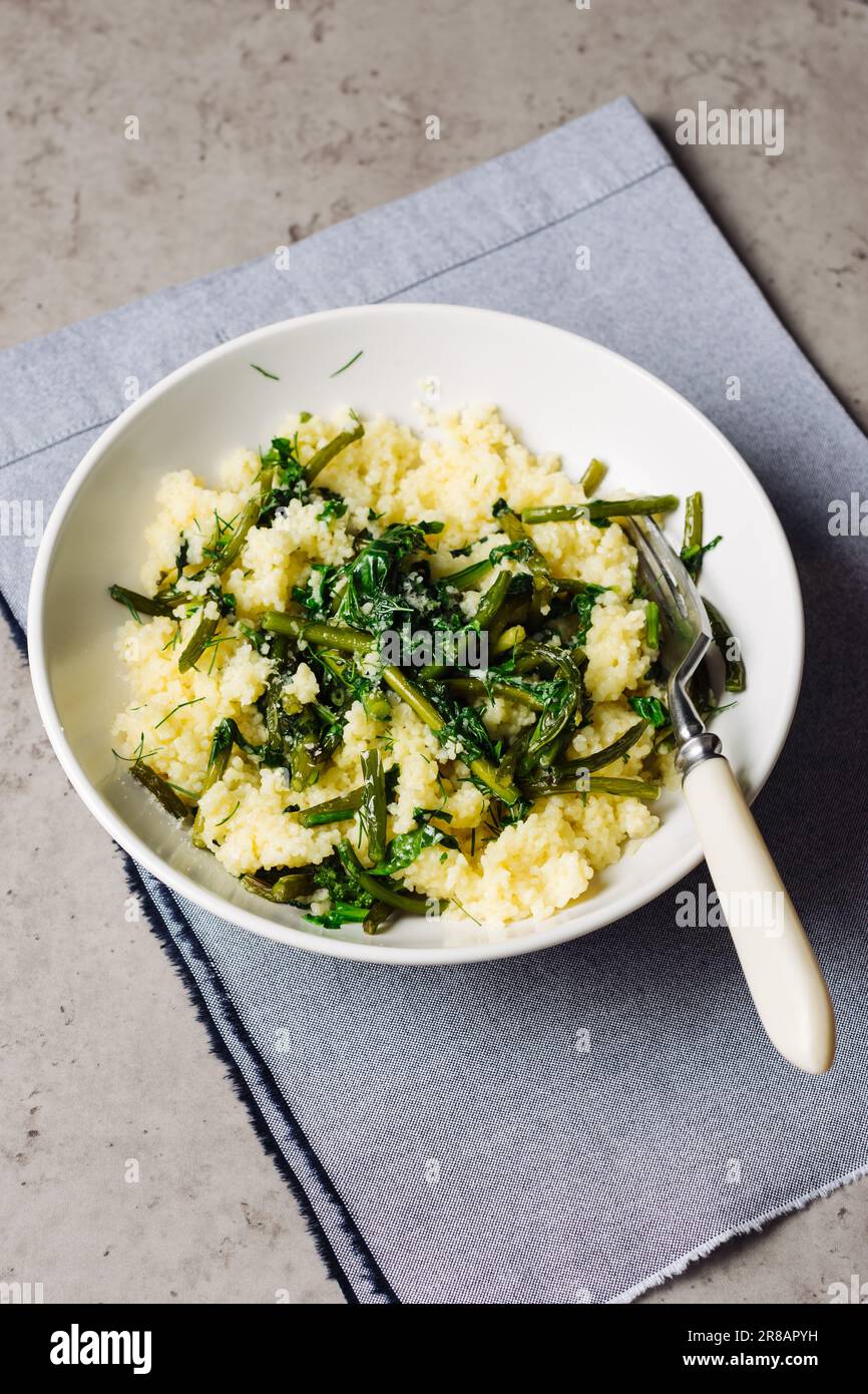 Couscous with garlic arrows and spinach. Vegan food Stock Photo - Alamy