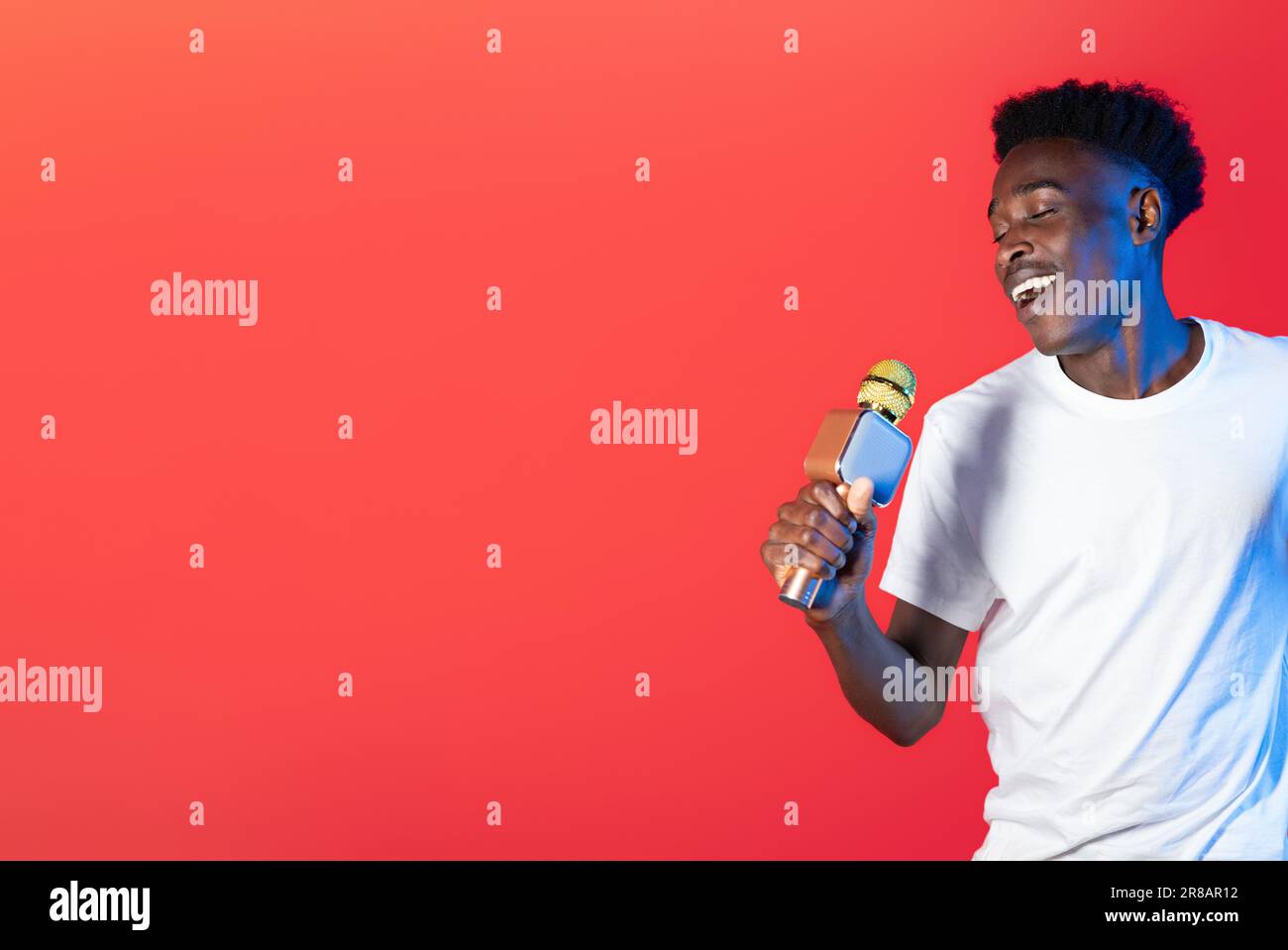 Charismatic black man singer performing on red, copy space Stock Photo ...