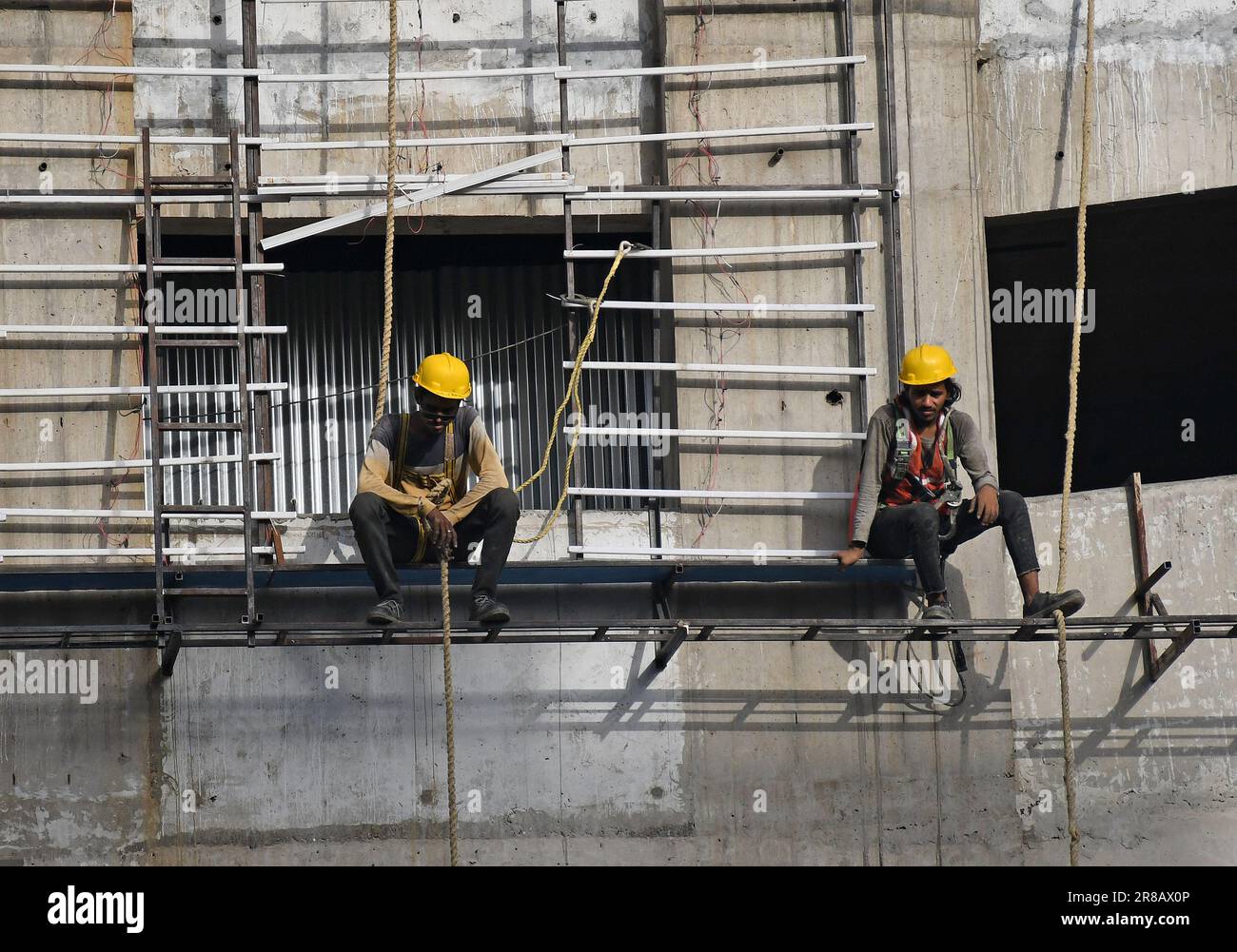 Labourers are seen sitting on a makeshift plank at a construction site ...