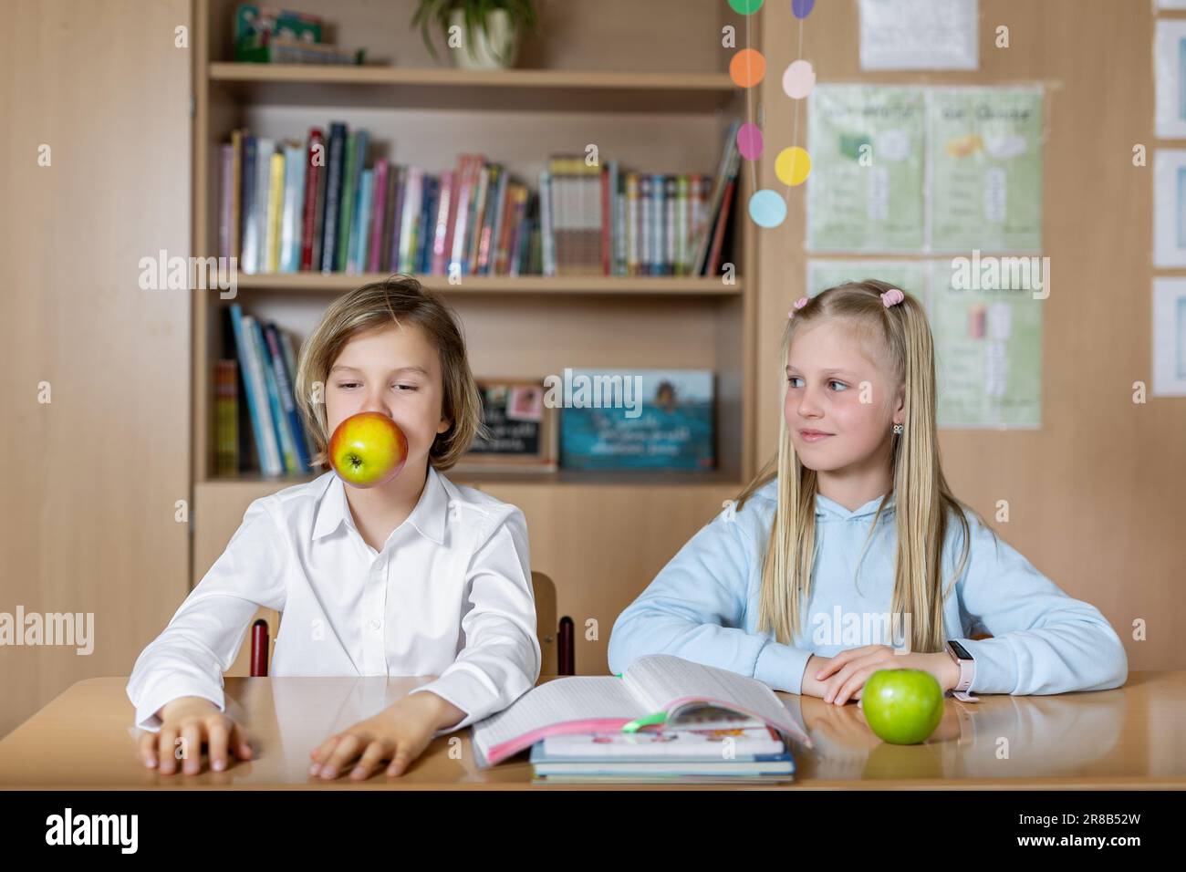 Portrait of two cute caucasian young blond little classmate friend kids ...