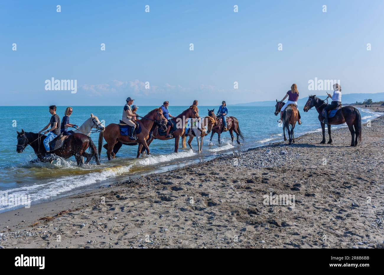Policoro, Italy - 7 May 2023: People riding horses in a Policoro beach ...