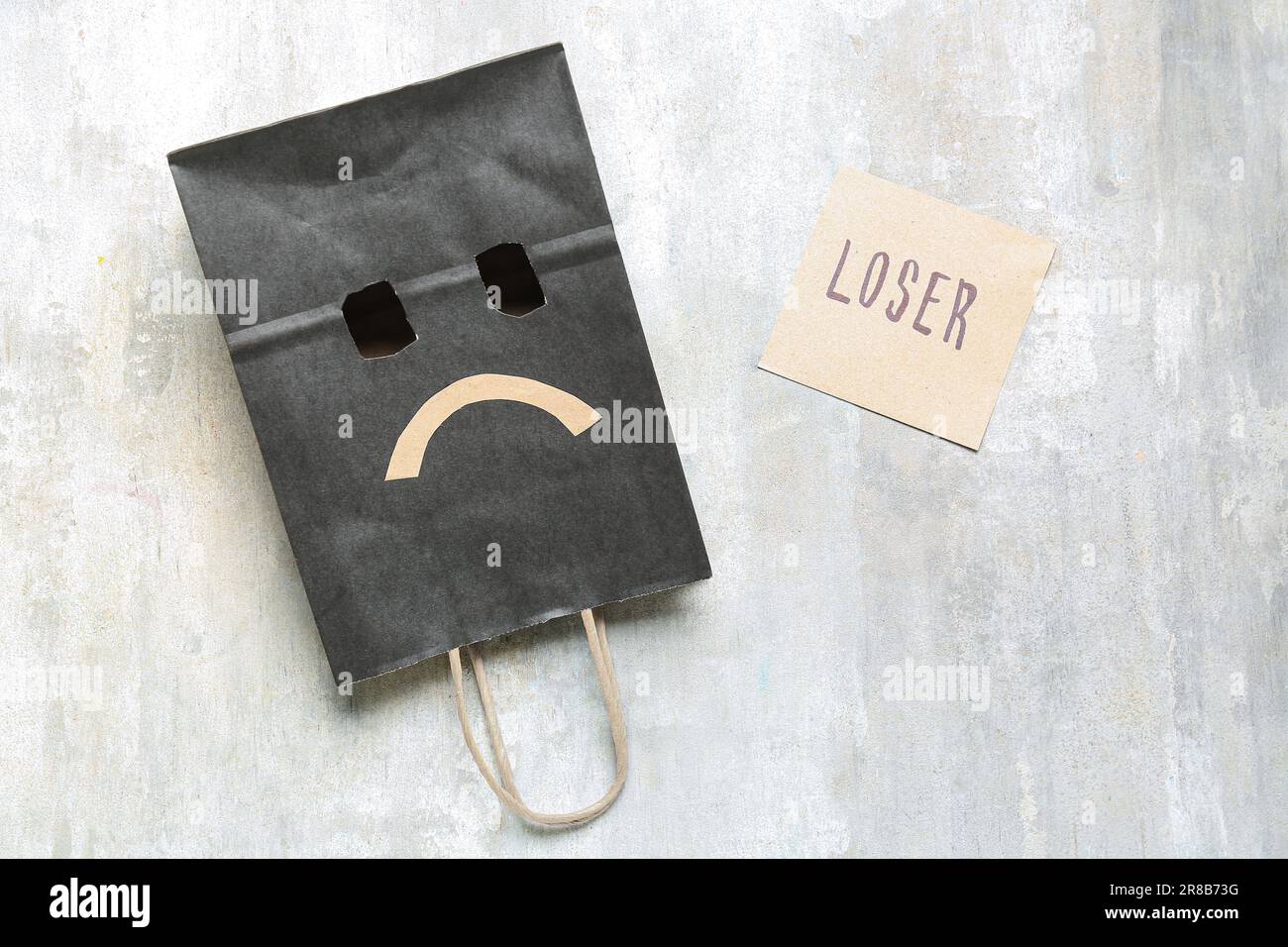 Paper bag with sad smile and word LOSER on grunge background Stock ...