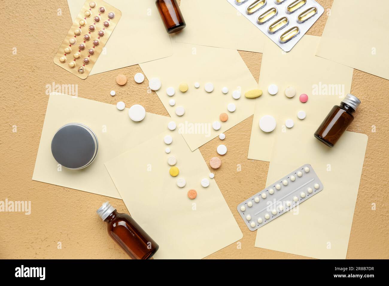 Uterus made of pills, medications and paper sheets on beige background ...