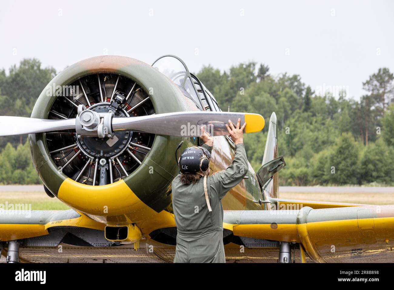 A business-savvy man working on an aircraft with a large propeller ...