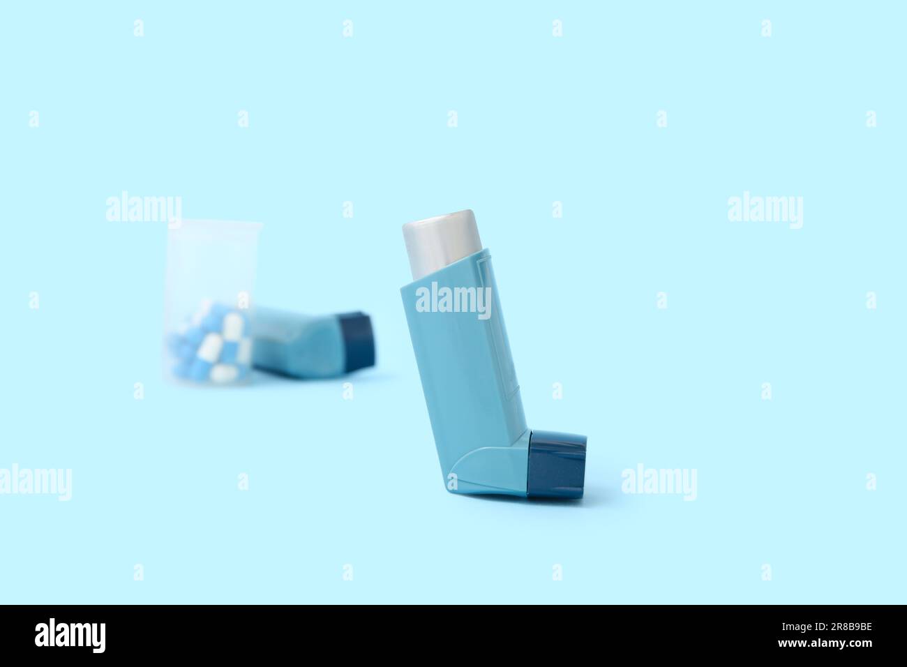 Asthma inhalers and box of pills on blue background Stock Photo - Alamy