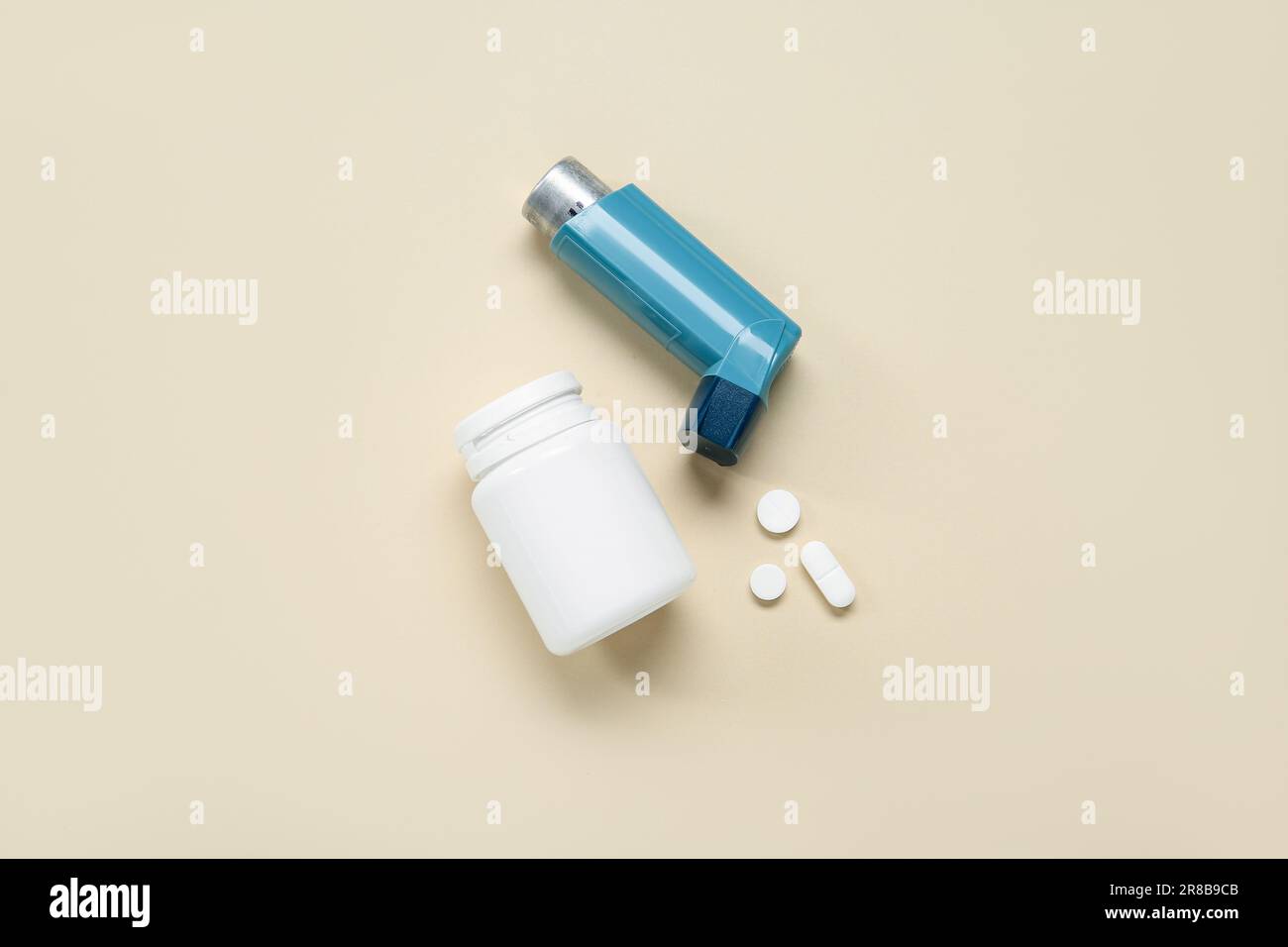 Asthma inhaler and box with pills on beige background Stock Photo - Alamy