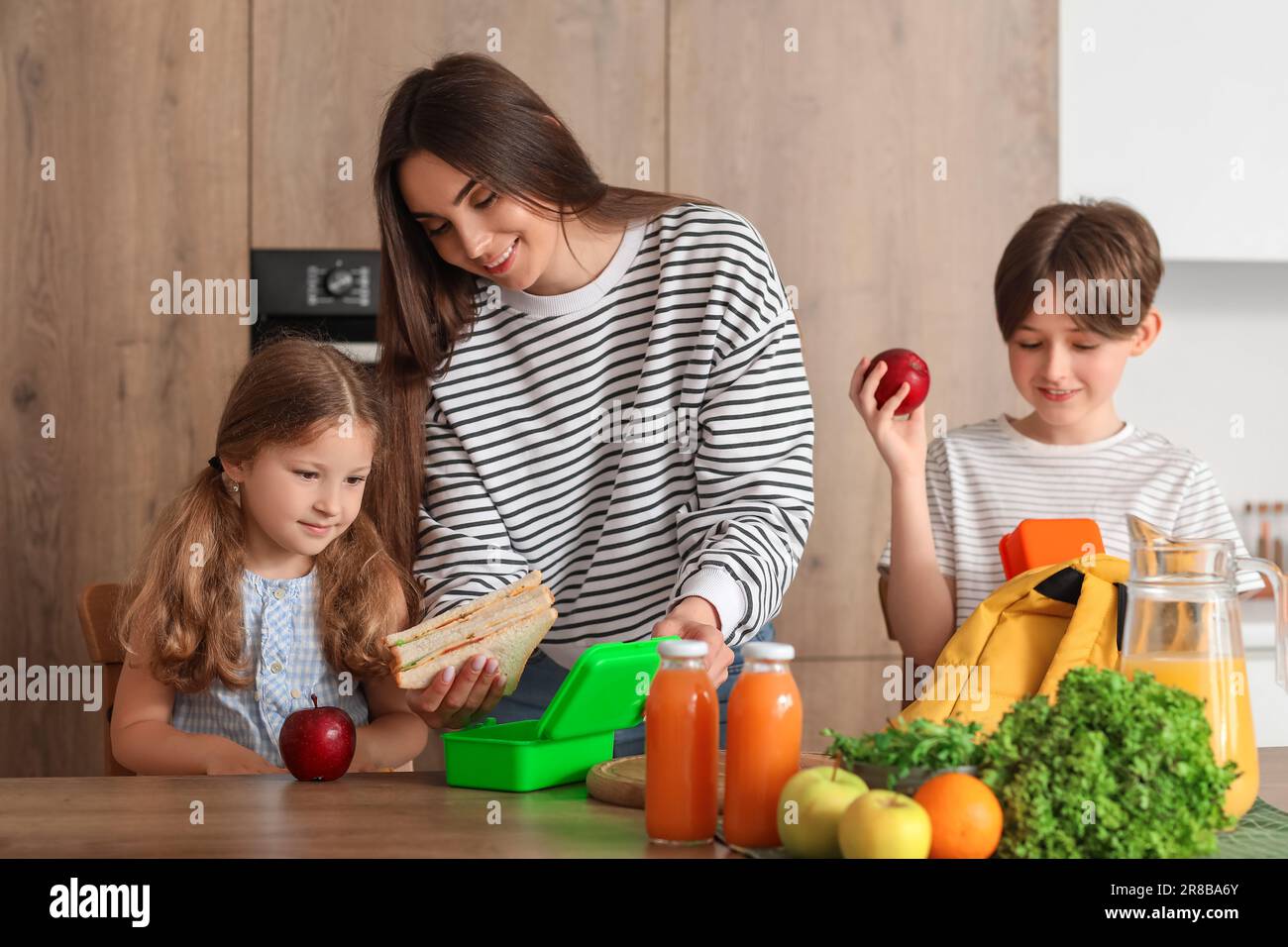 Mother packing school lunch for her little children in kitchen Stock ...
