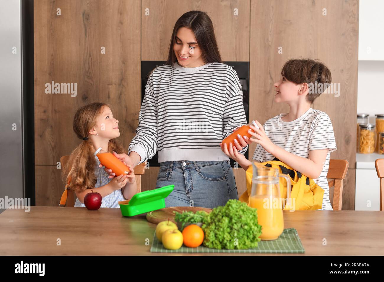 Mother packing school lunch for her little children in kitchen Stock ...