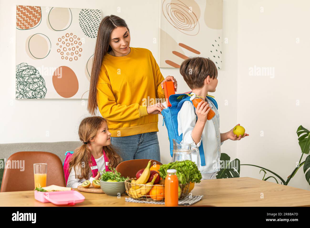 Mother packing school lunch for her little children in kitchen Stock ...