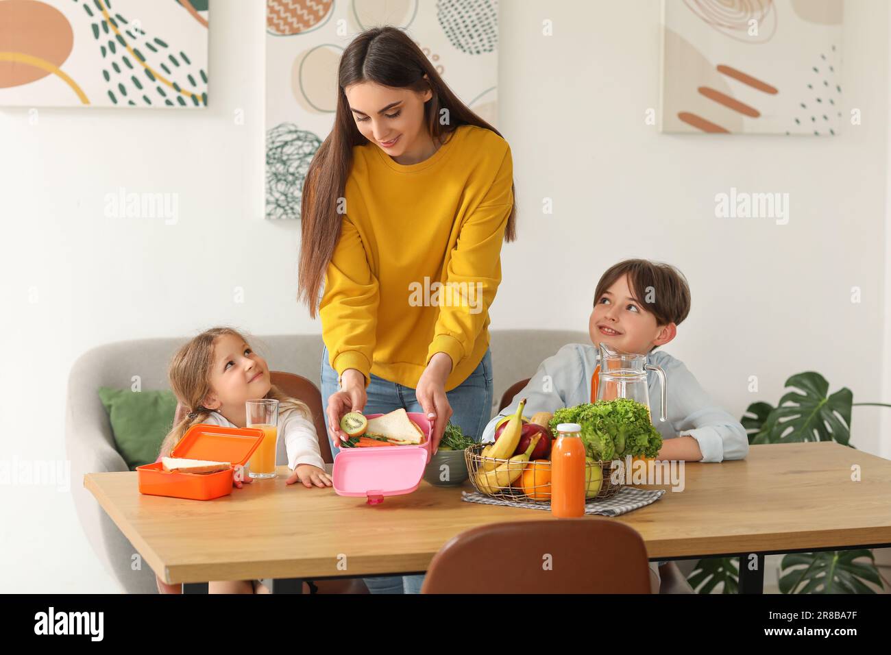 Mother packing school lunch for her little children in kitchen Stock ...