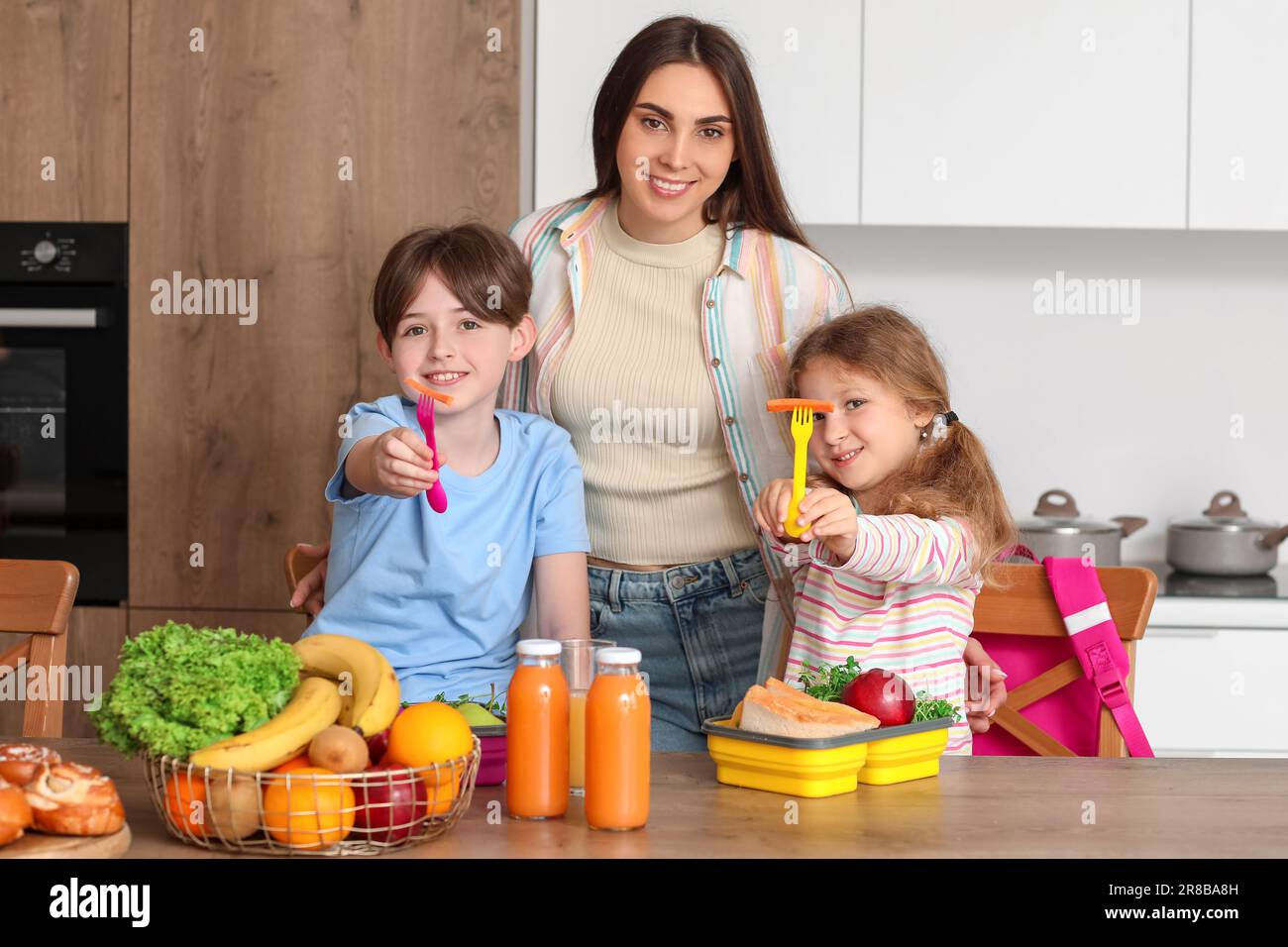 Mother packing school lunch for her little children in kitchen Stock ...