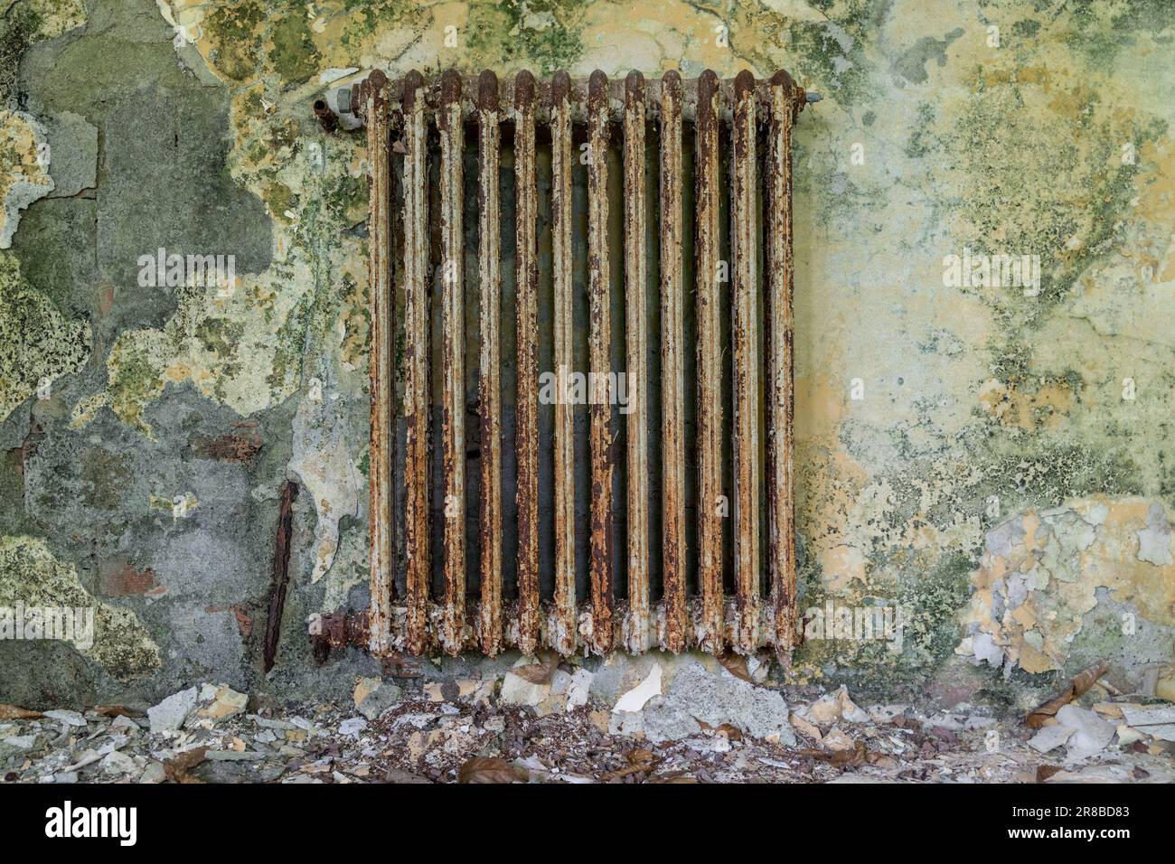 Old rusty radiator on a wall with peeling plaster Stock Photo - Alamy