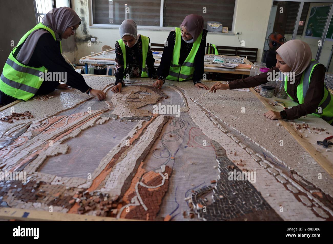 Palestinian girls arranges tiles into a mosaic mural at aassociation in ...