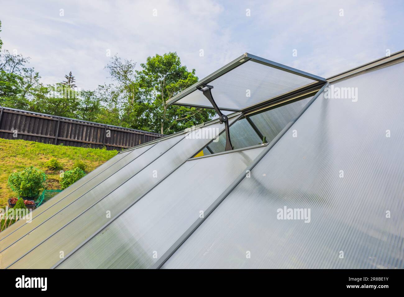 View of greenhouse in private garden with open window on ceiling for ...