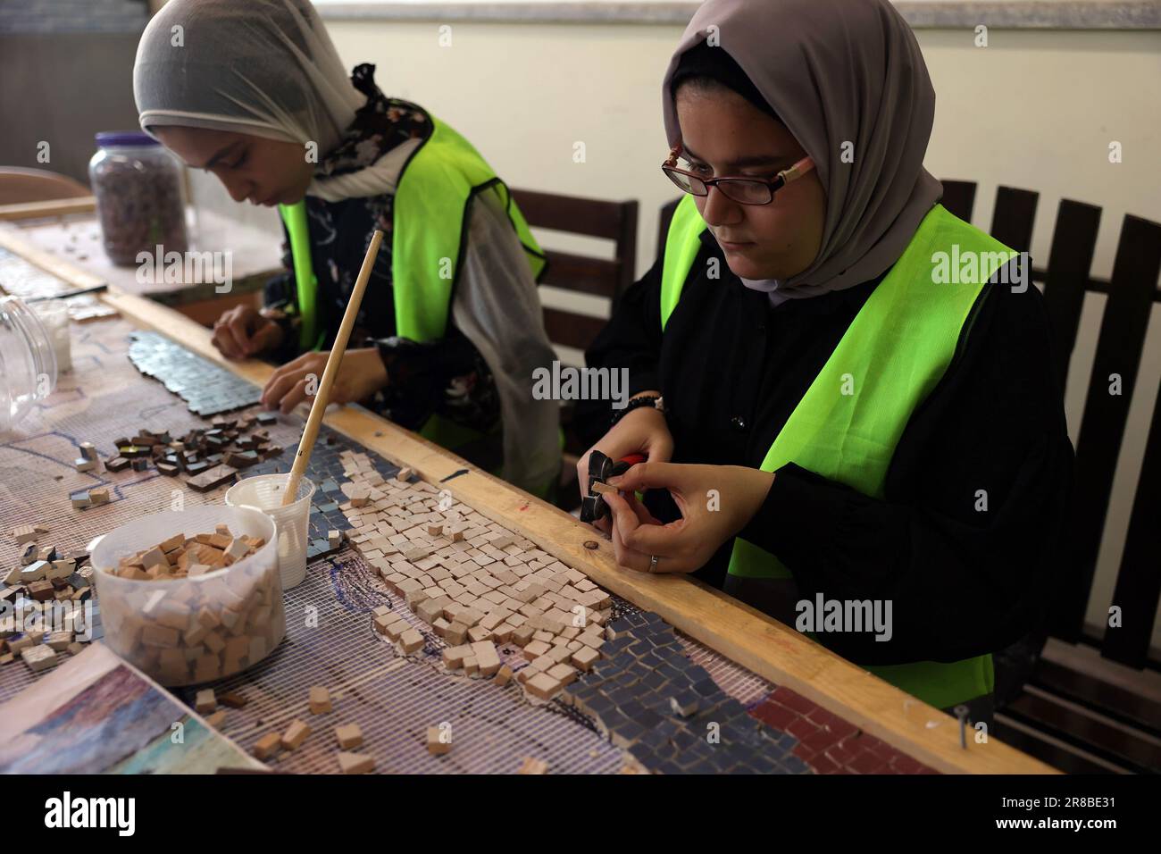 Palestinian girls arranges tiles into a mosaic mural at aassociation in ...