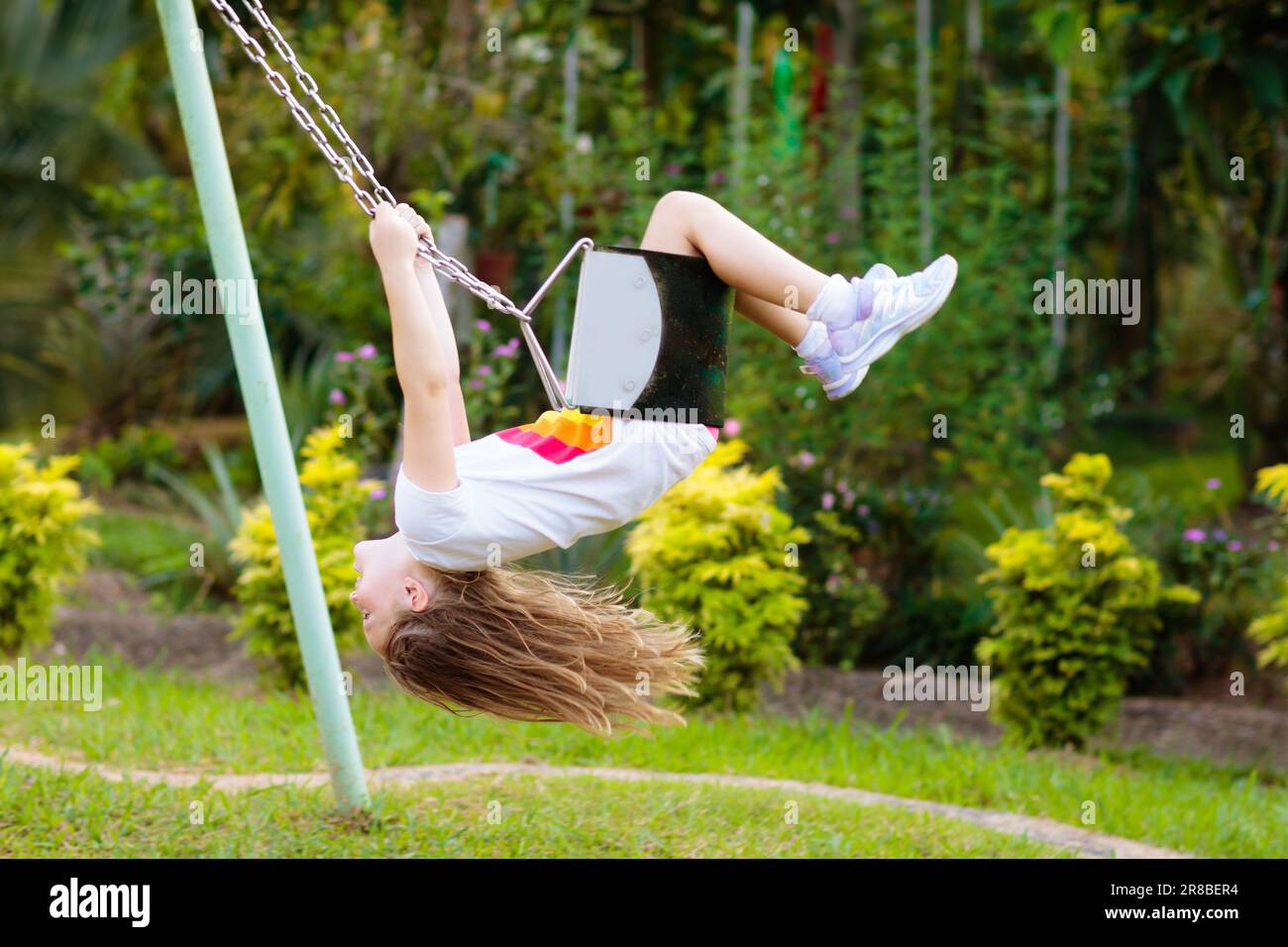 Child swinging on playground on sunny summer day in a park. Kids swing ...