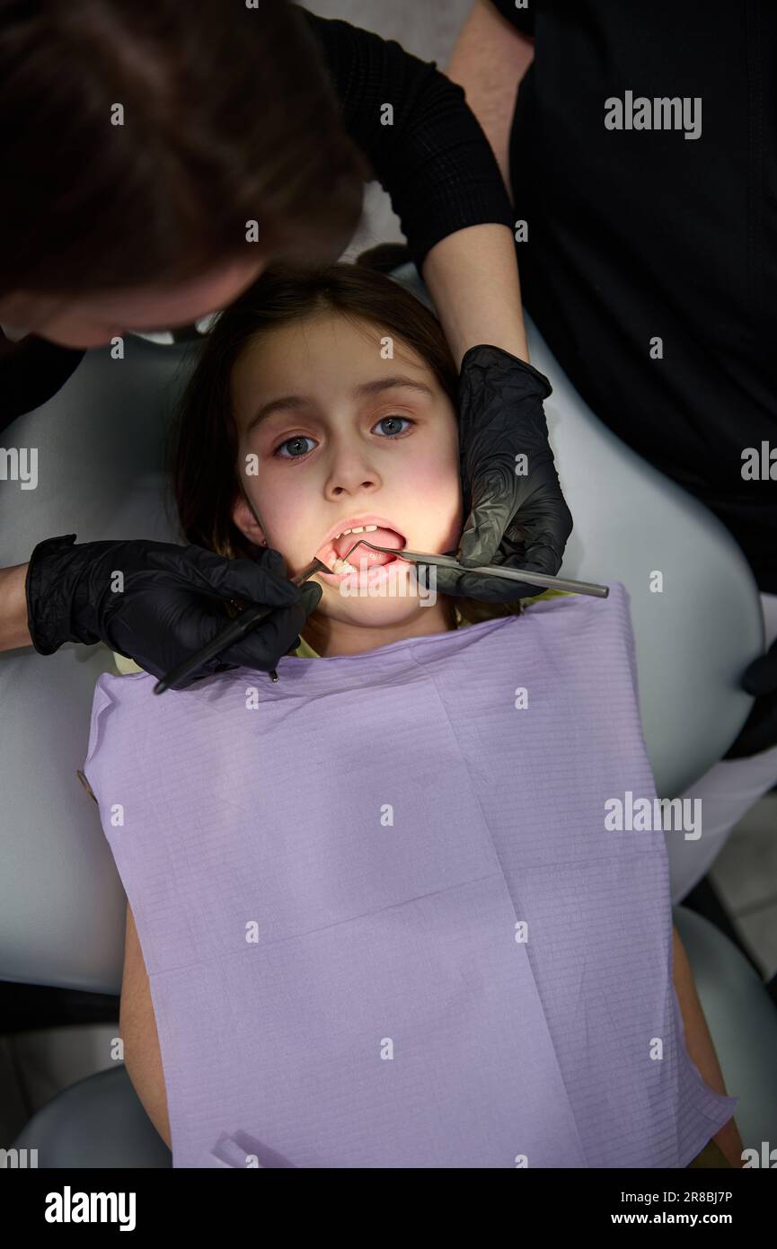 Treatment of baby teeth. Little girl with open mouth during dental ...