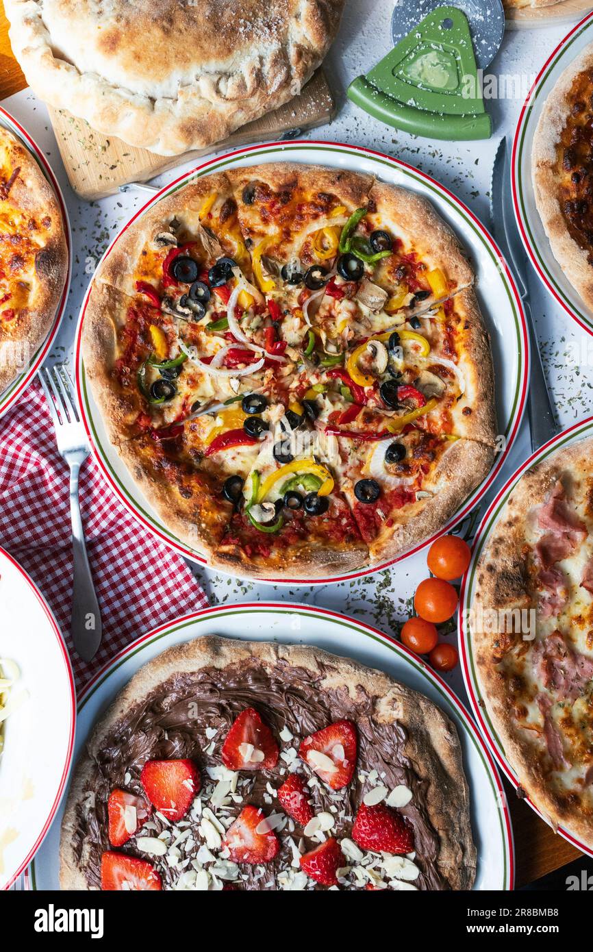 Table with various types of pizza. Vertical image Stock Photo - Alamy