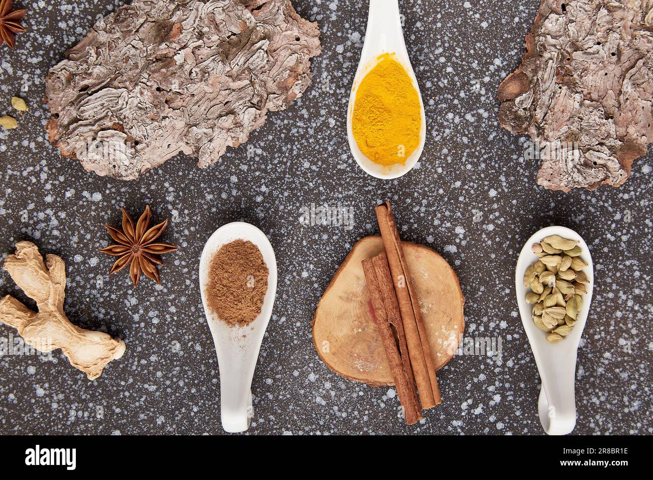 Assortment on natural black background - turmeric, cinnamon, cardamom ...