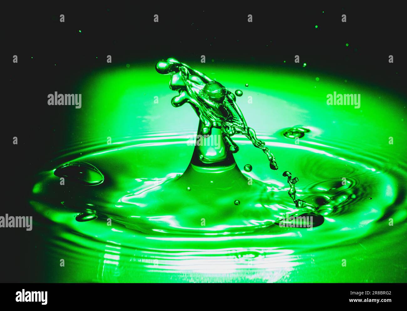 A close-up of a single water droplet with a neon green hue Stock Photo ...